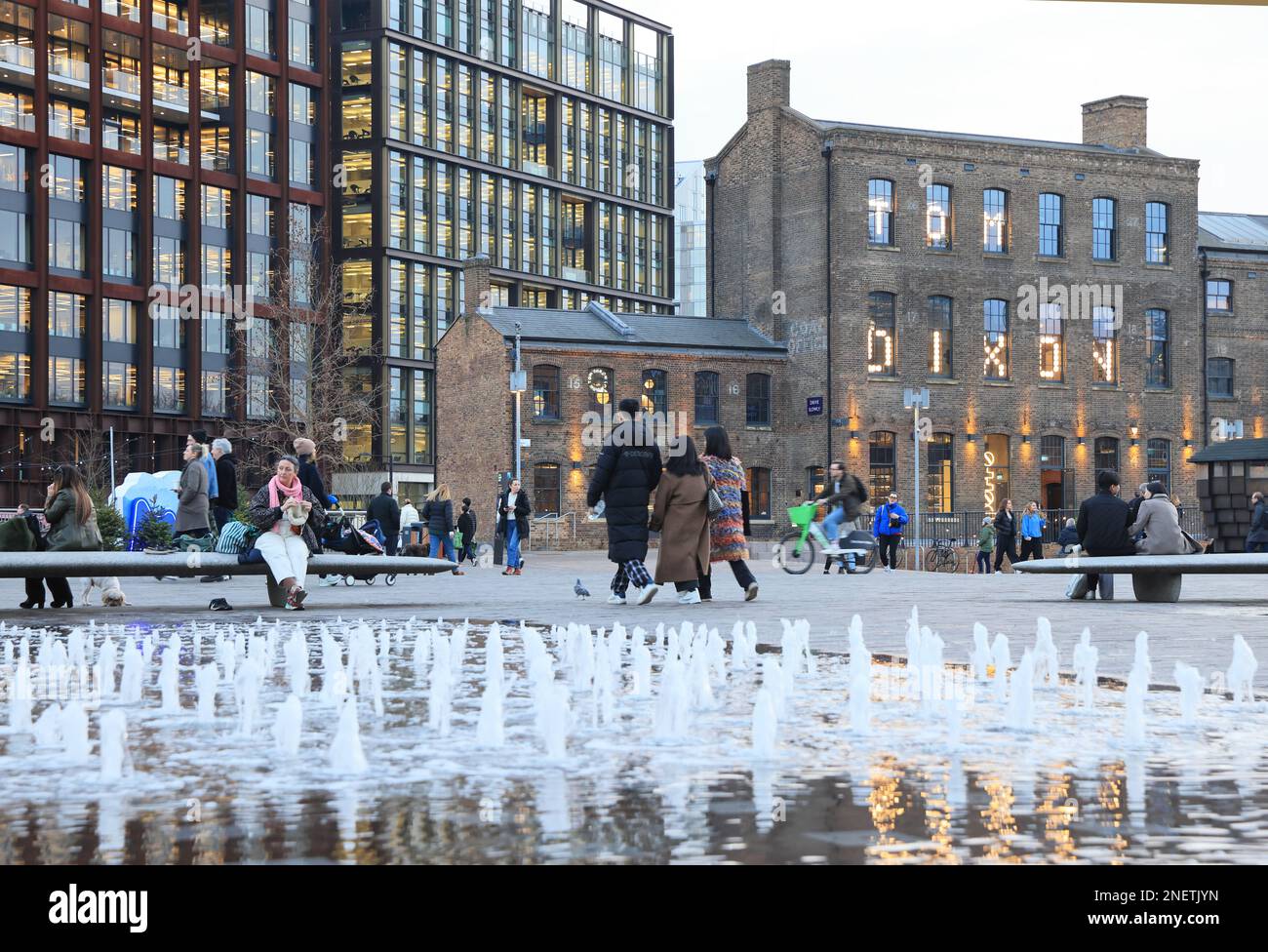 View across fountains in Granary Square, in late afternoon winter ...