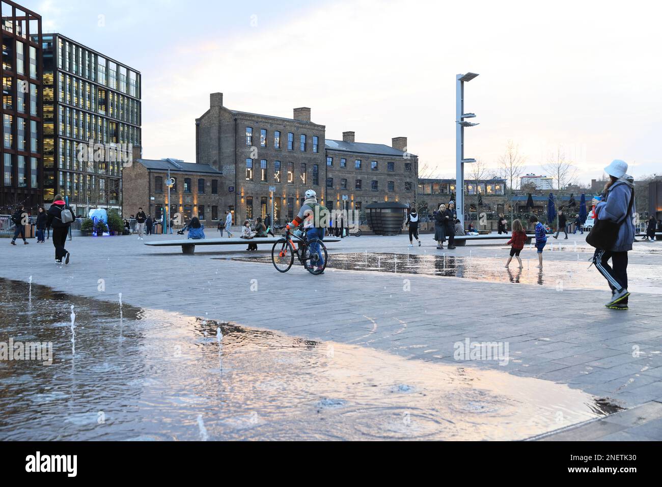 View across fountains in Granary Square, in late afternoon winter ...