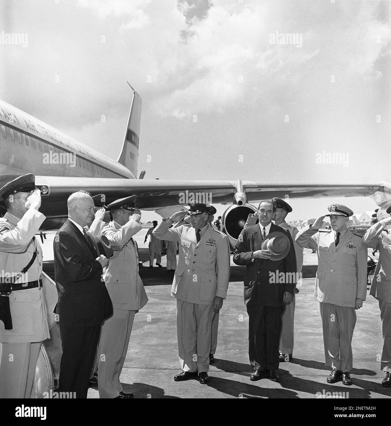 President Dwight Eisenhower stands at attention and Air Force personnel ...