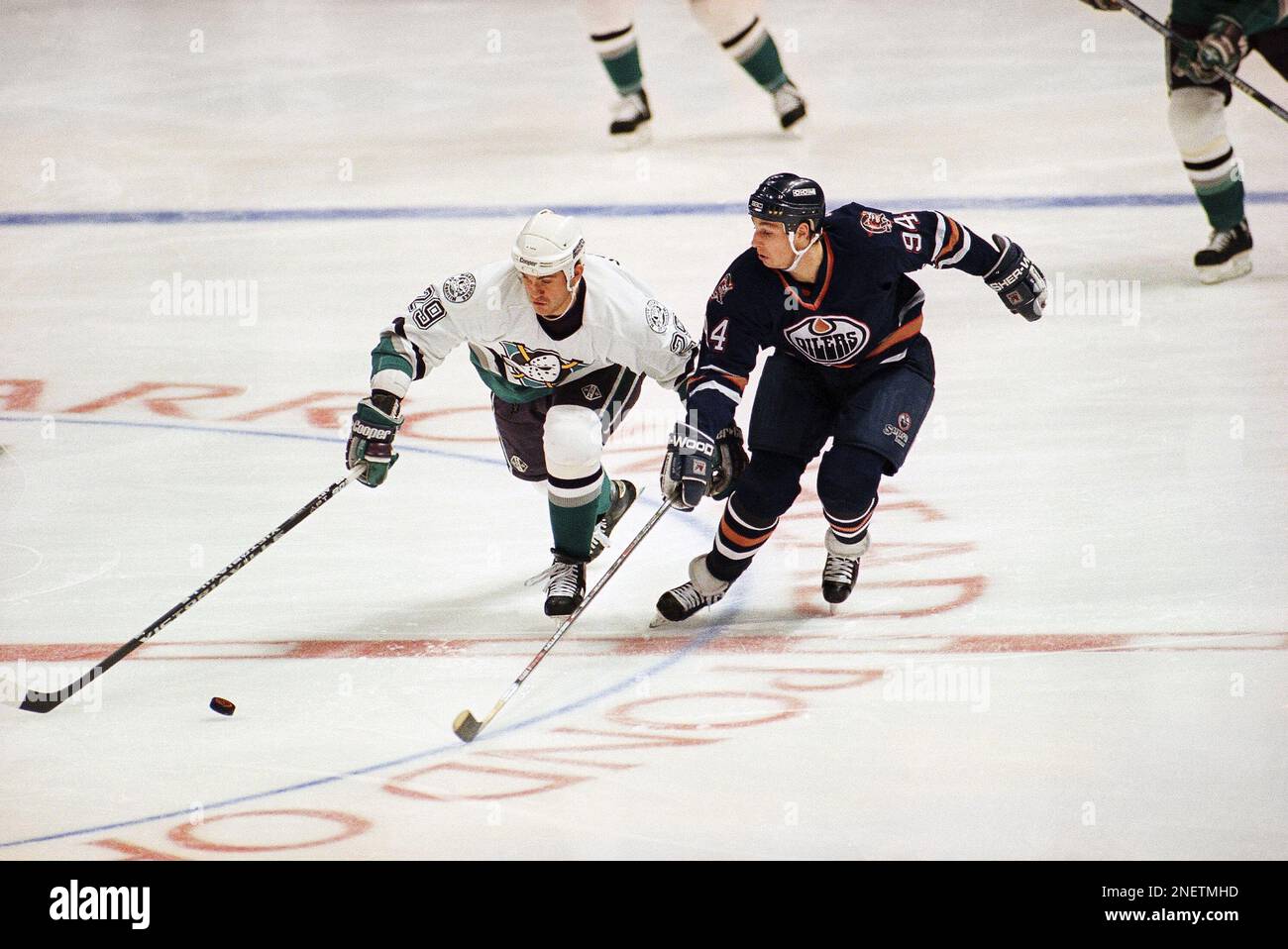 Mighty Ducks’ Darren Van Impe and Edmonton Oilers’ Ryan Smith chase the ...