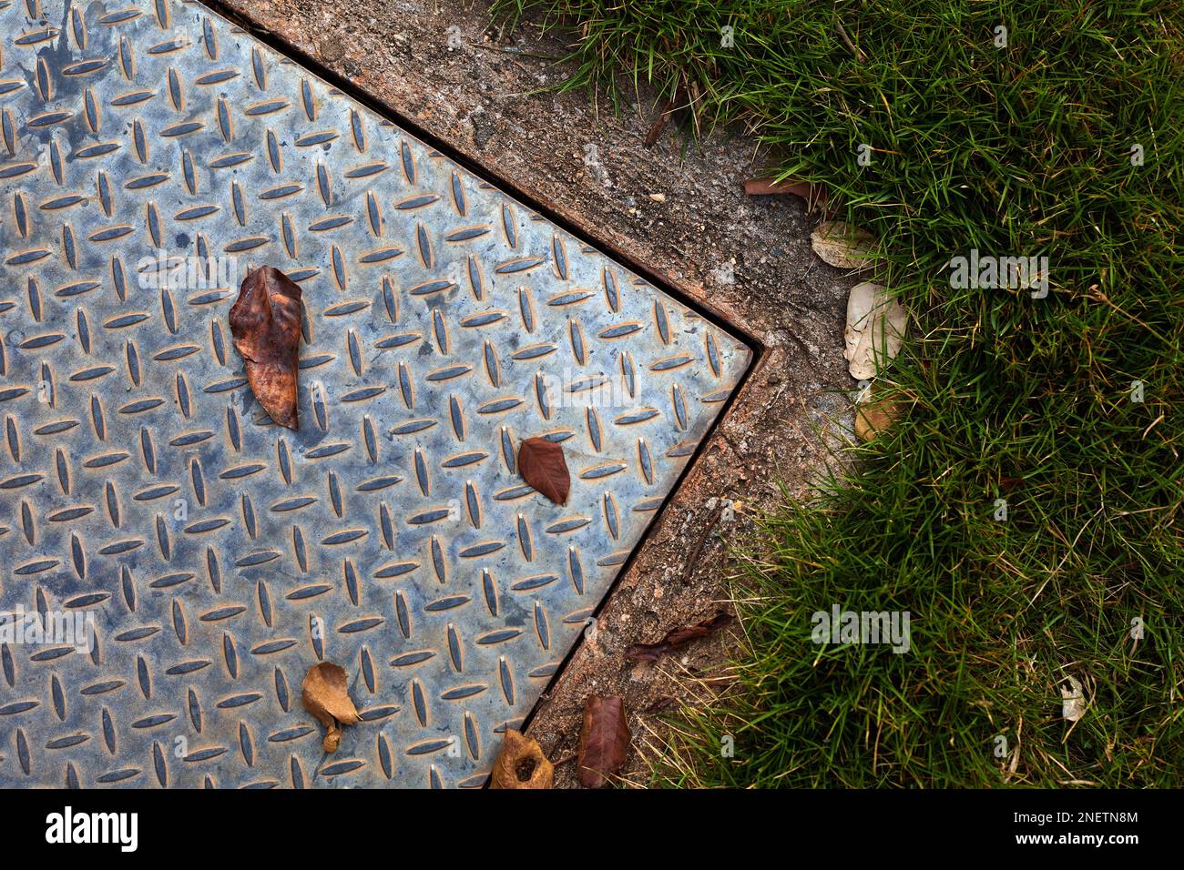 Steel pavement to the edge of the cement and lawn Stock Photo - Alamy