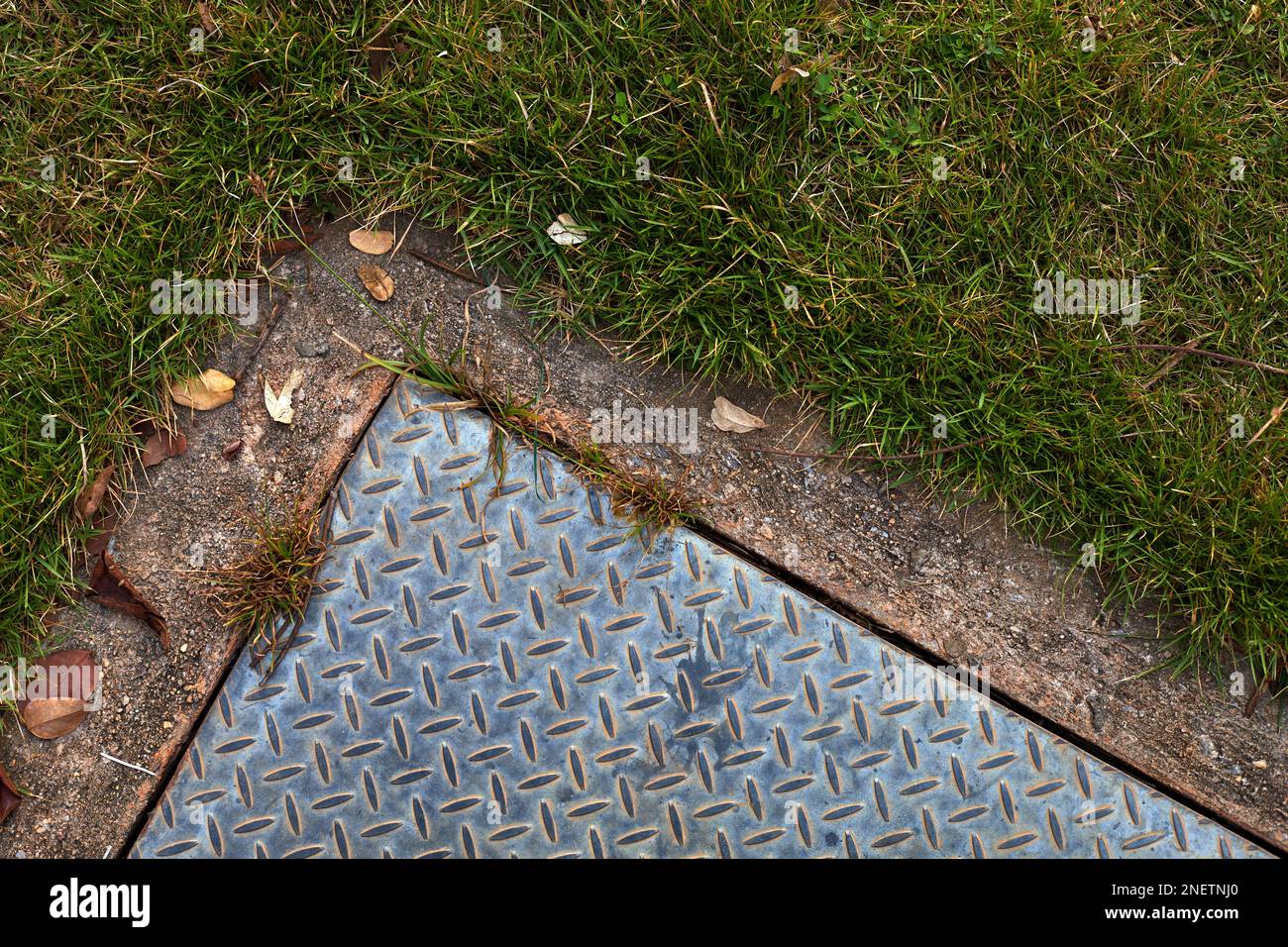Steel pavement to the edge of the cement and lawn Stock Photo - Alamy