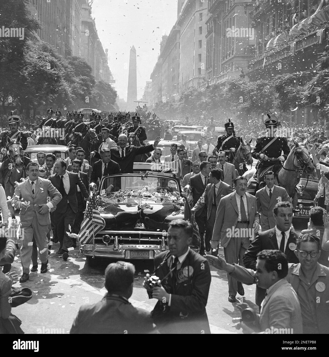 President Dwight Eisenhower waves from open auto as he rides through ...