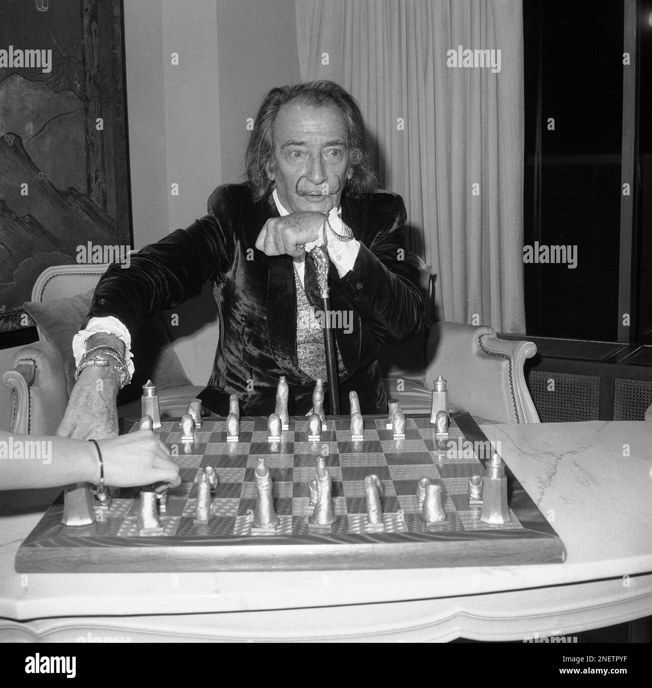 Renowned artist Salvador Dali looks over a chess set designed by F.J ...