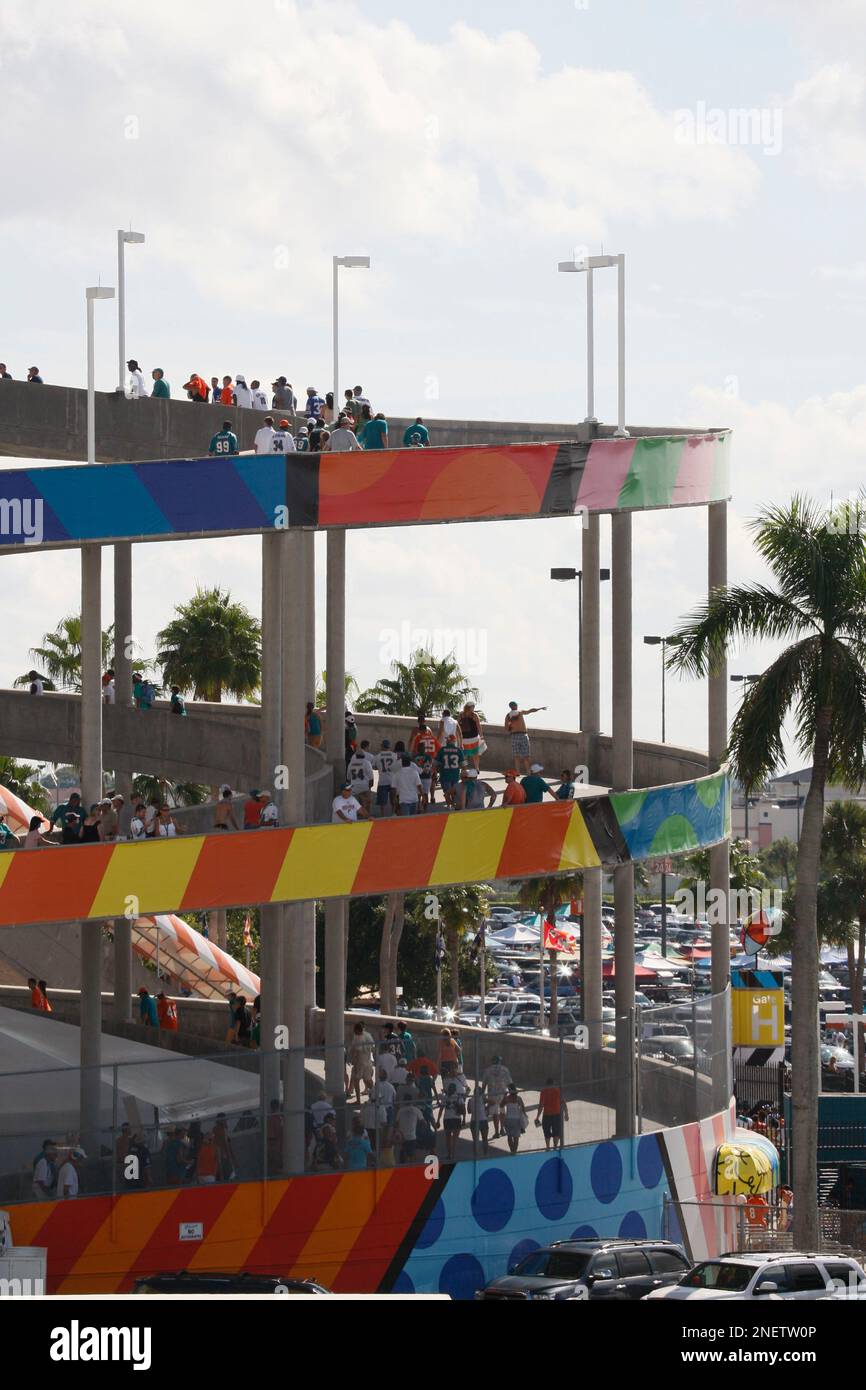 Football fans walk up a ramp painted with designs by artist Romero ...