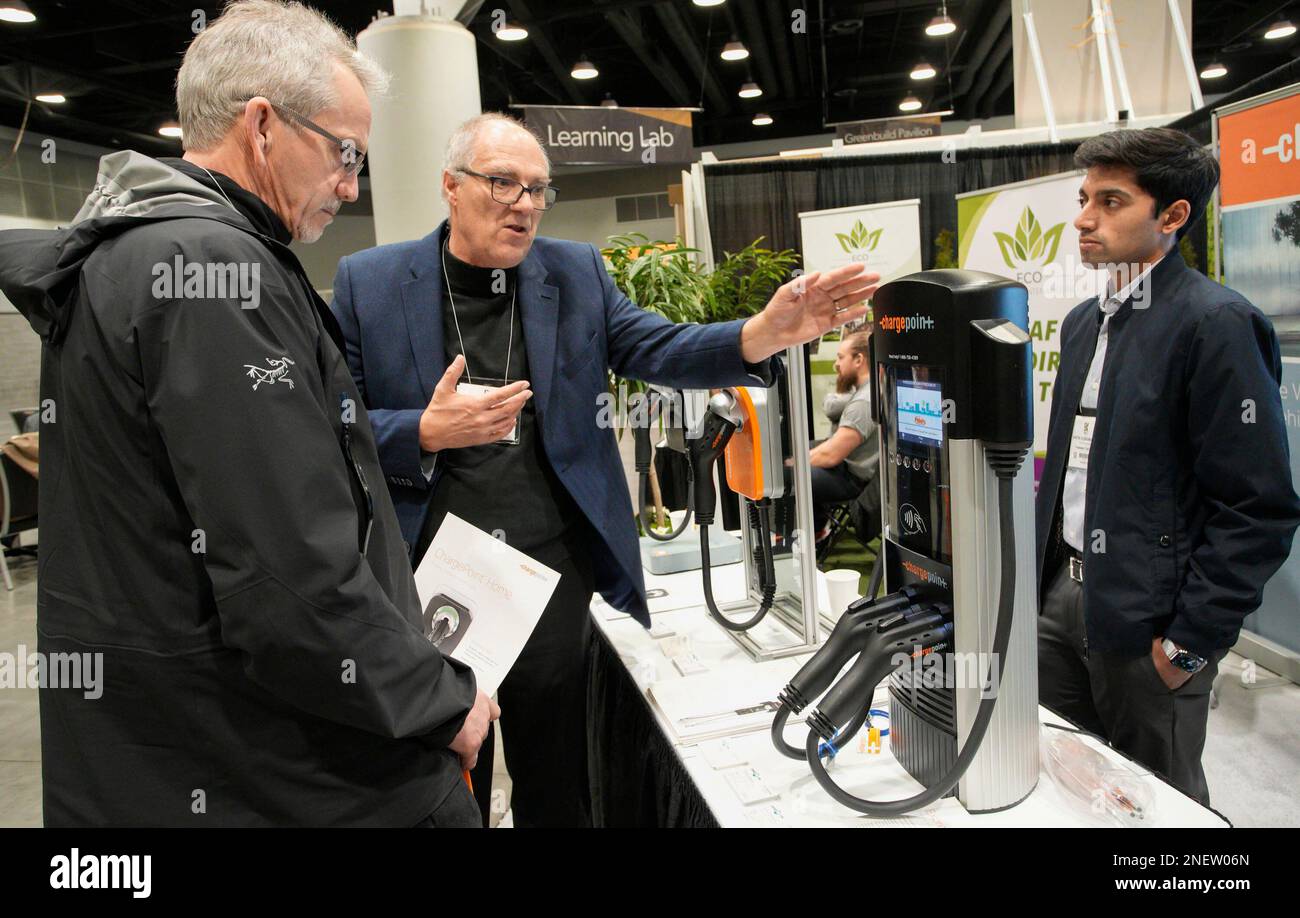 Vancouver, Canada. 16th Feb, 2023. A visitor (L) looks at EV car ...