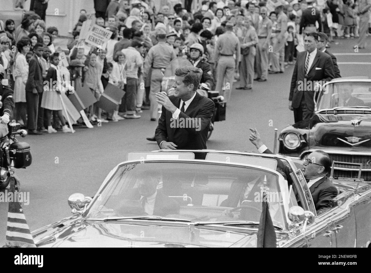 President John F. Kennedy waves from his car during a parade through ...