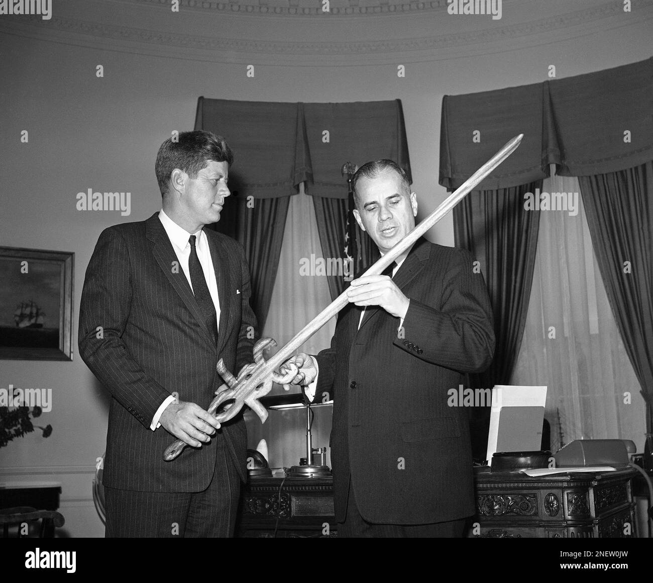 President Kennedy looks over a five-foot sword made of Hawaiian monkey ...