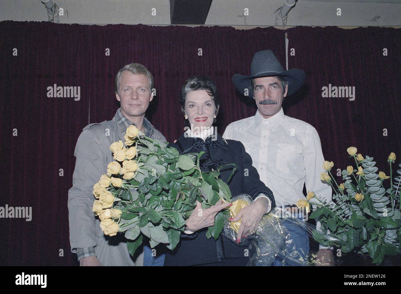 Actress Jane Russell holds a bouquet of yellow roses with actors David ...