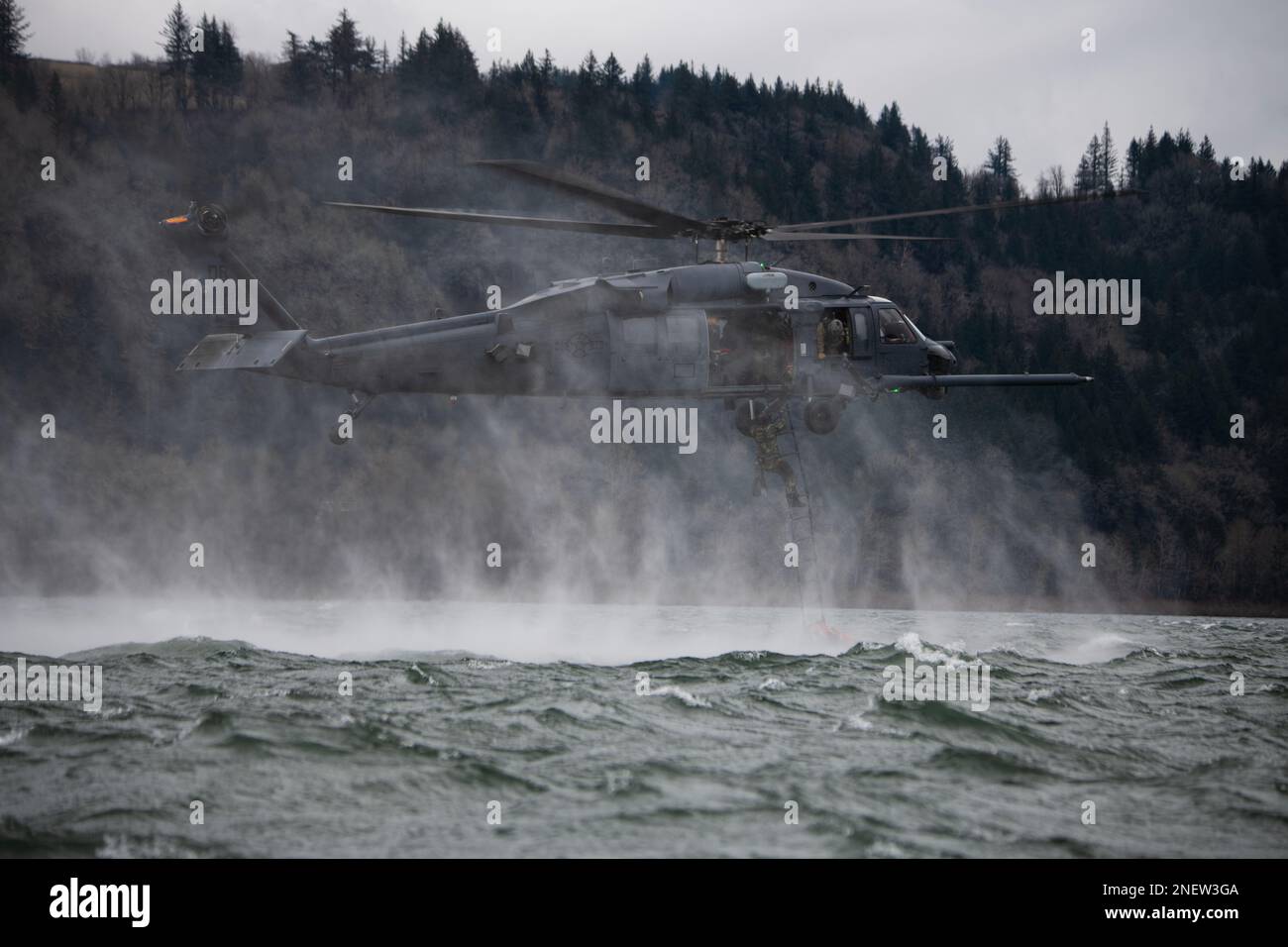 304th Rescue Squadron pararescuemen ascend a rope ladder connected to a ...