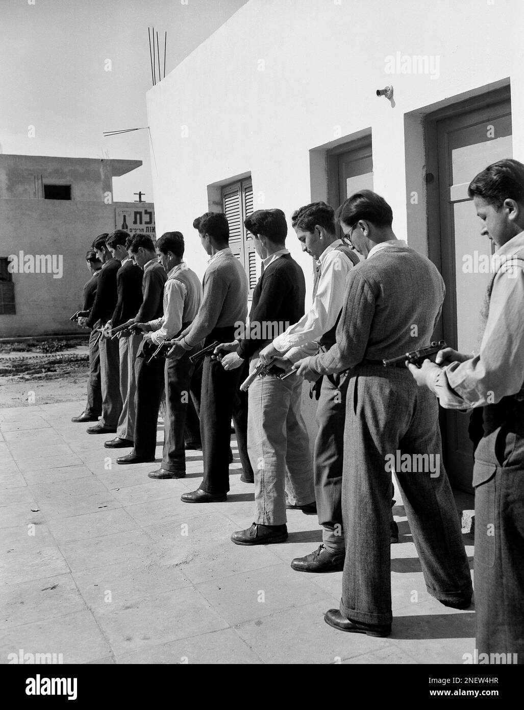 Loading up, Irgun trainees are shown how to handle pistols which is ...
