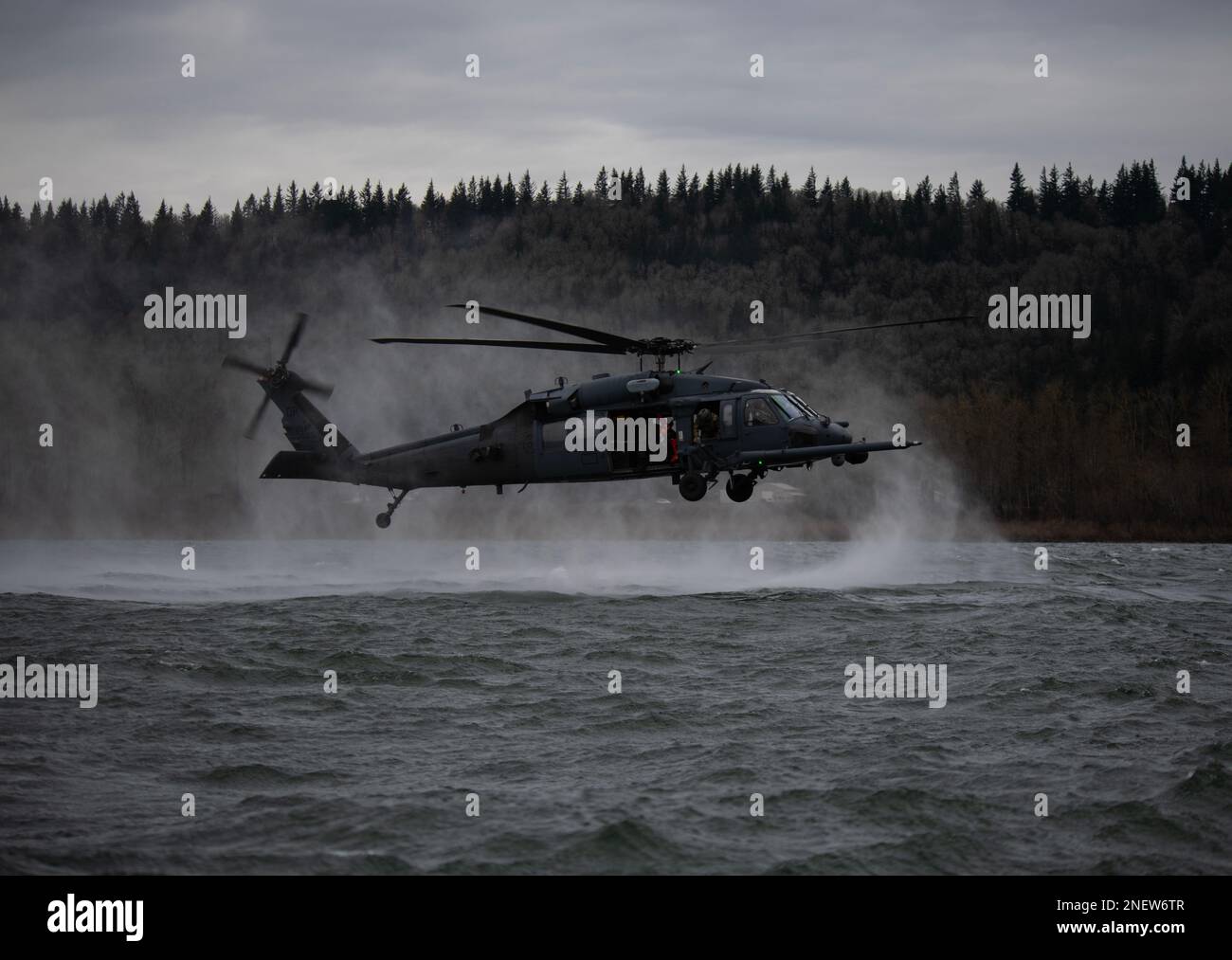 A 305th Rescue Squadron HH-60G Pave Hawk helicopter hovers over a ...