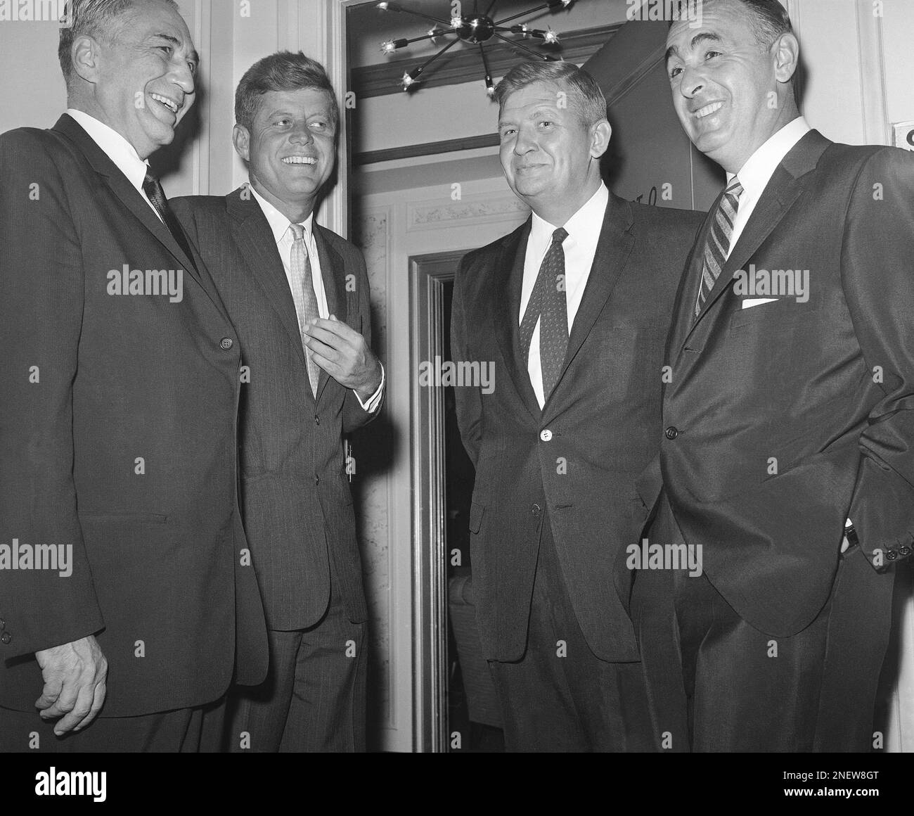 Sen. John F. Kennedy, left, of Massachusetts poses with two of his many ...