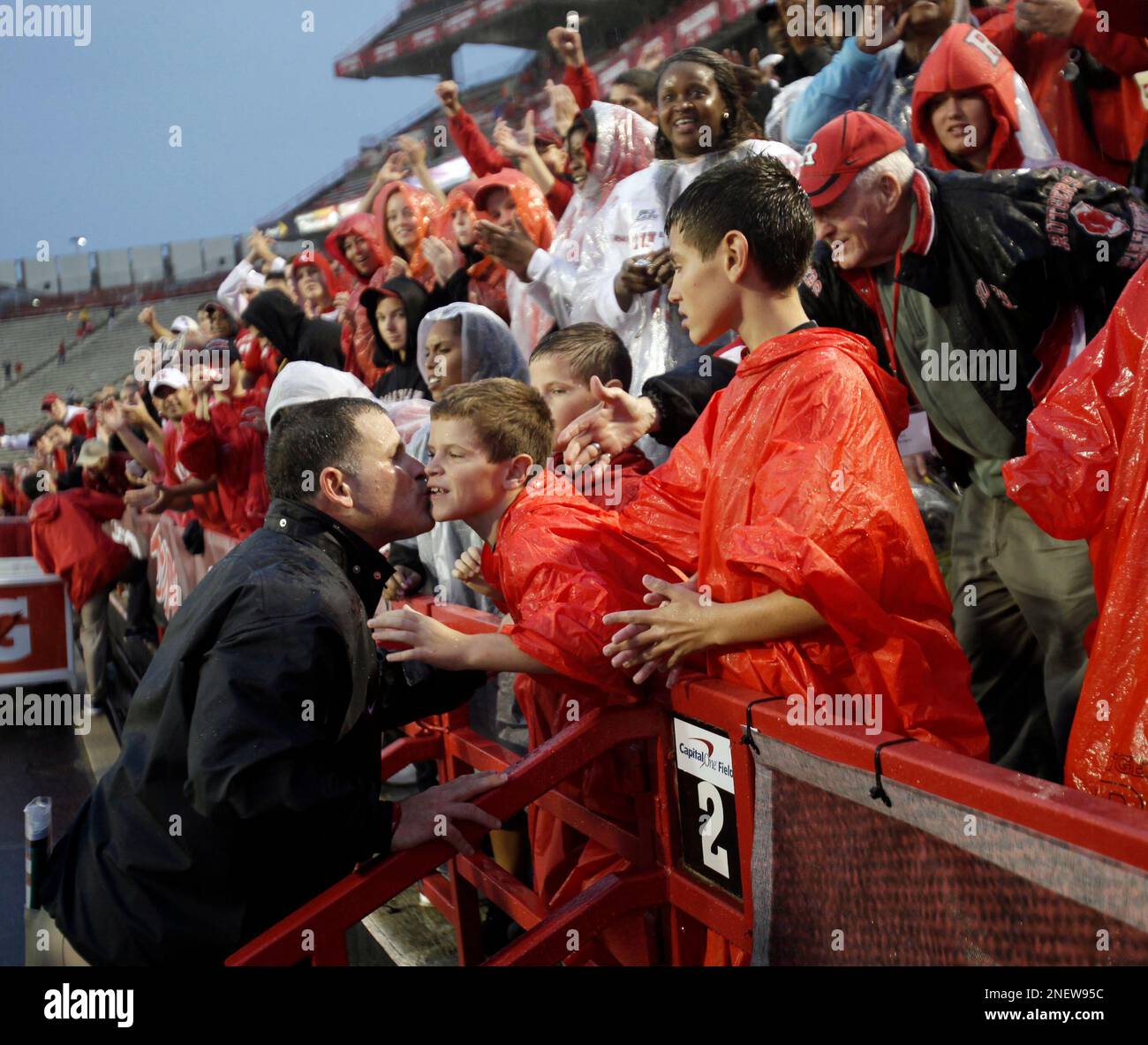 Rutgers coach Greg Schiano kisses one of his children after they ...