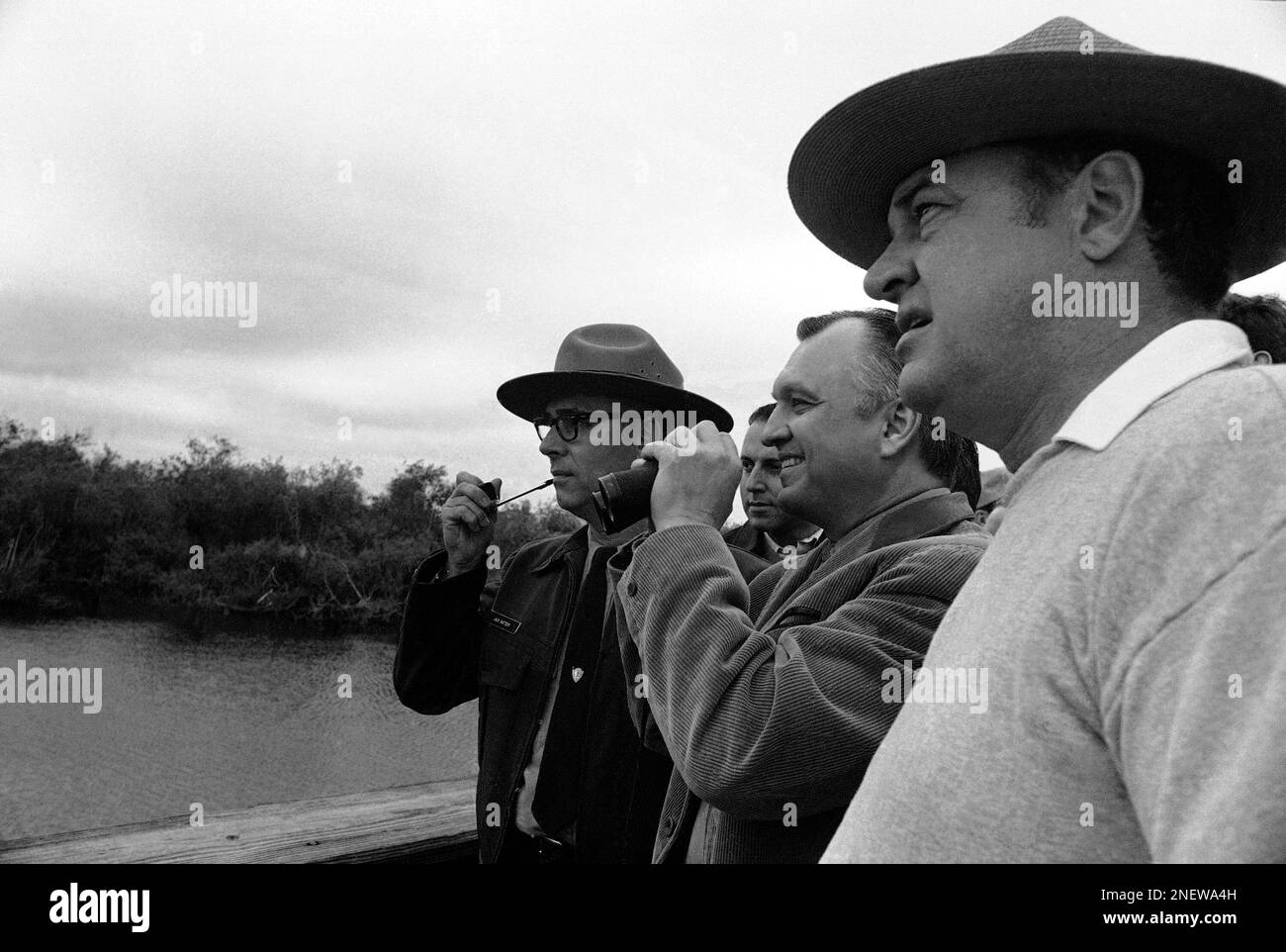 Interior Secretary Walter Hickel (center), with the aid of binoculars ...