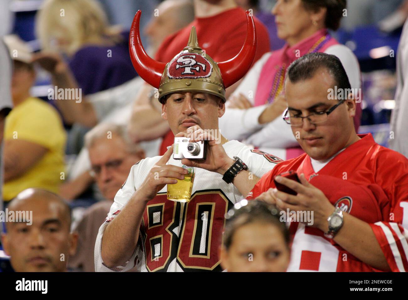 A San Francisco 49ers fans check their cameras during warm-ups before ...