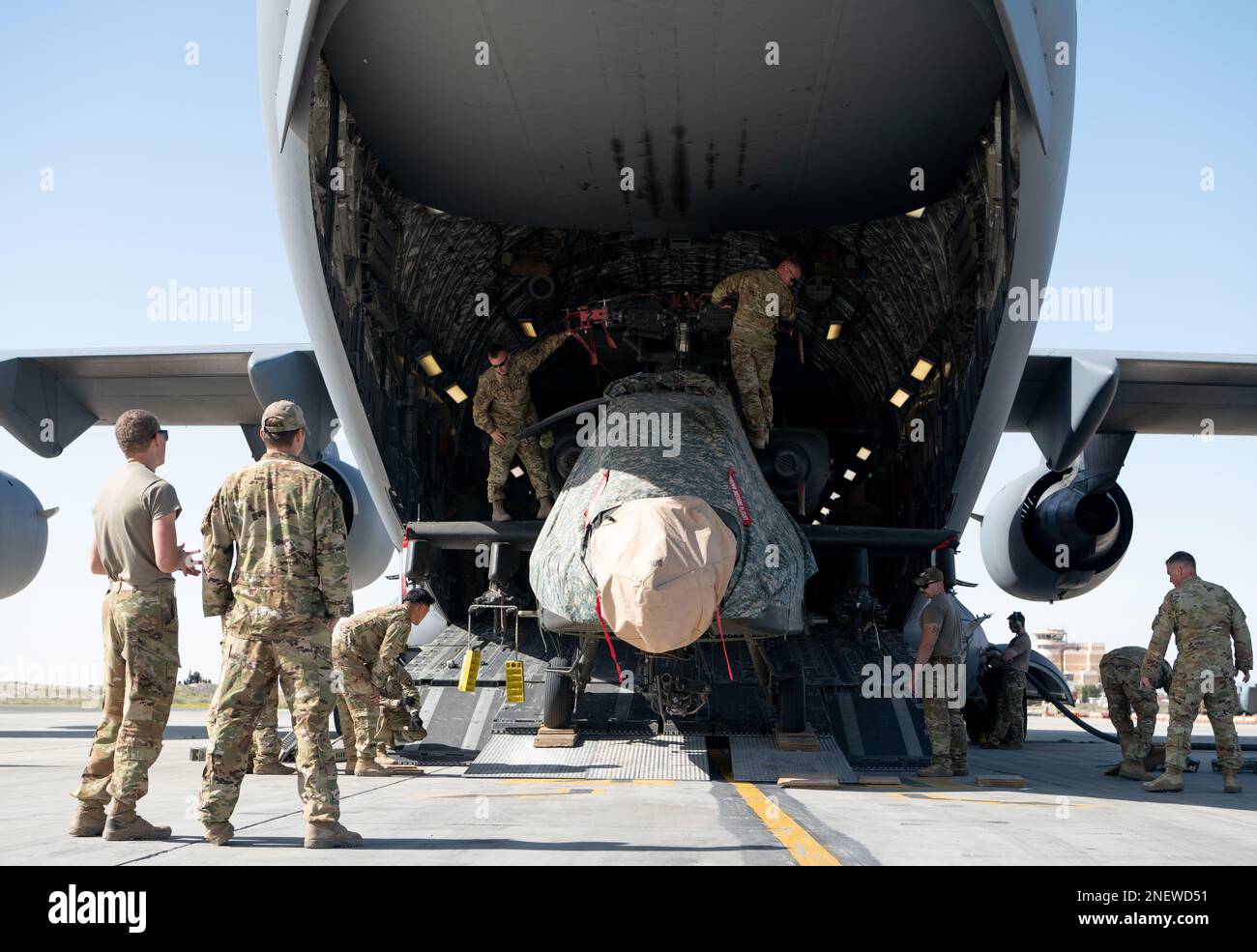 U.S. Airmen and Soldiers offload an AH-64D Apache Longbow helicopter ...