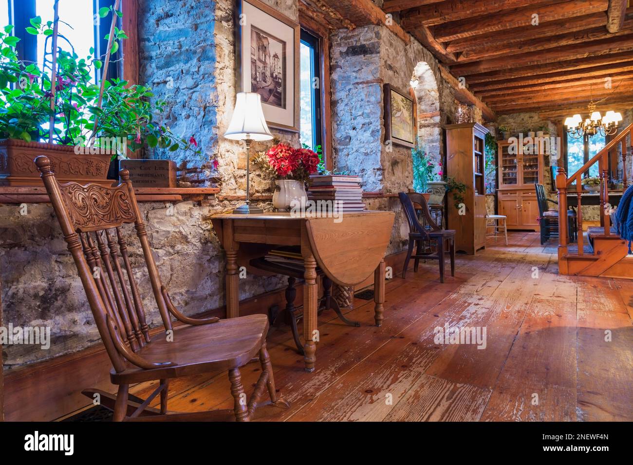 Antique rocking chair and table against a fieldstone wall in living ...