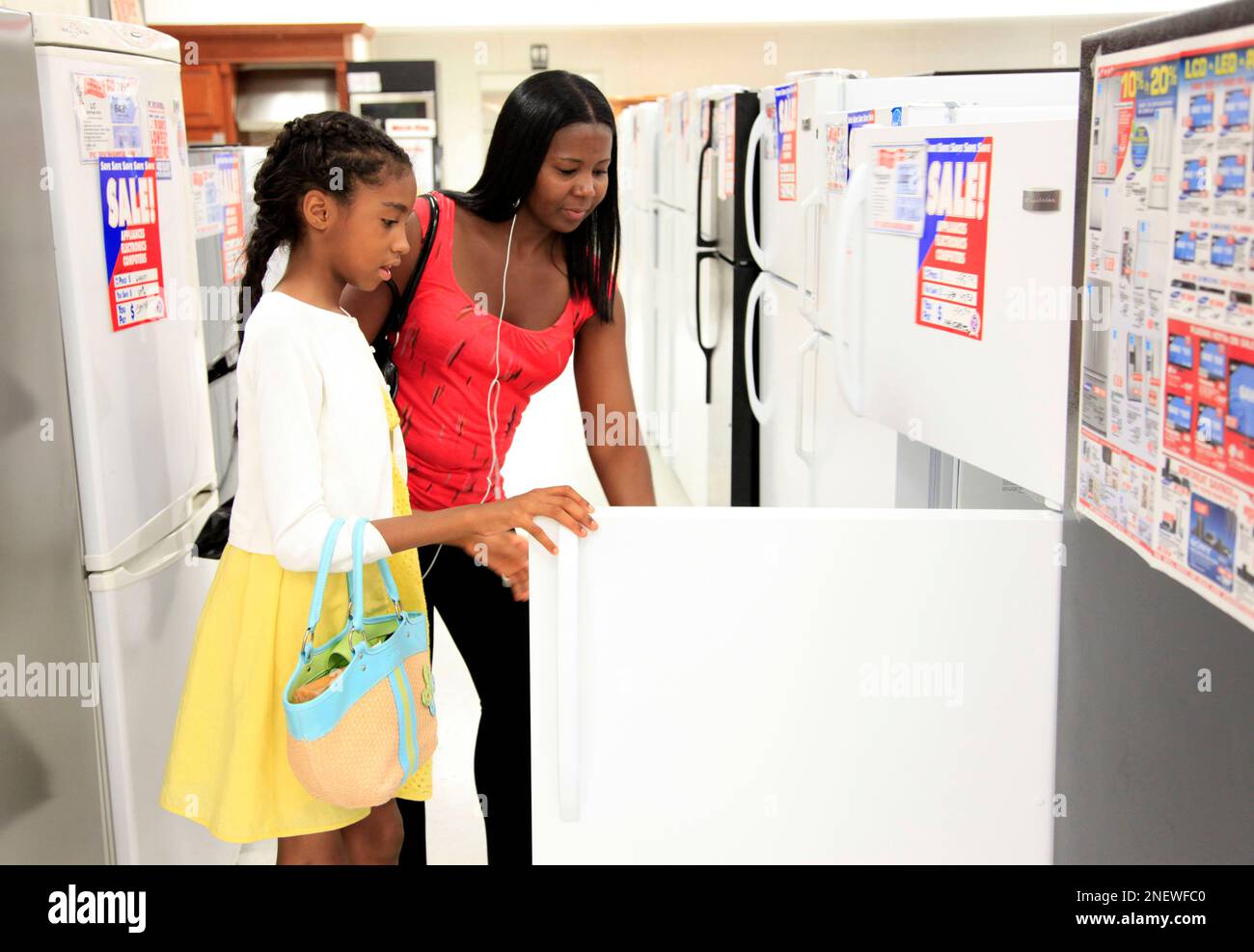 Aretha Fairweather and her daughter, Sukanya, 10, look at refrigerators ...
