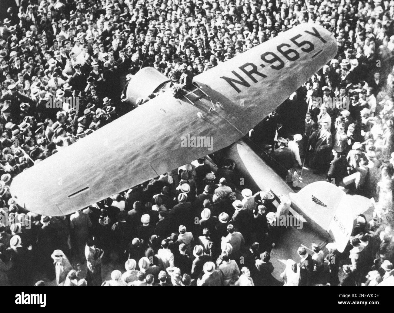 Amelia Earhart with her Lockheed Vega surrounded by crowd after she ...