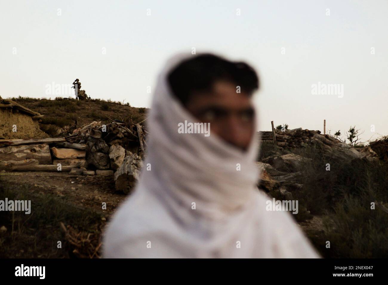 A villager looks on as soldiers from the U.S. Army's 3rd Battalion ...