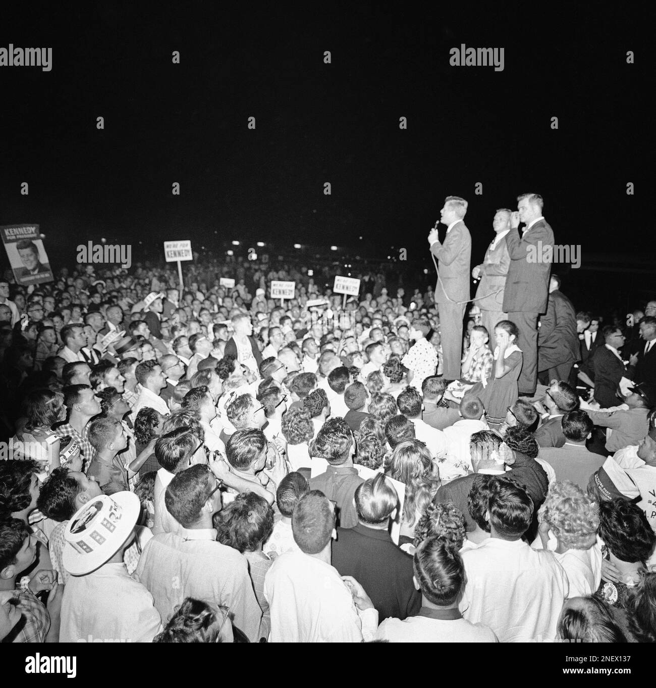 Sen. John F. Kennedy uses a microphone to address a crowd estimated at ...