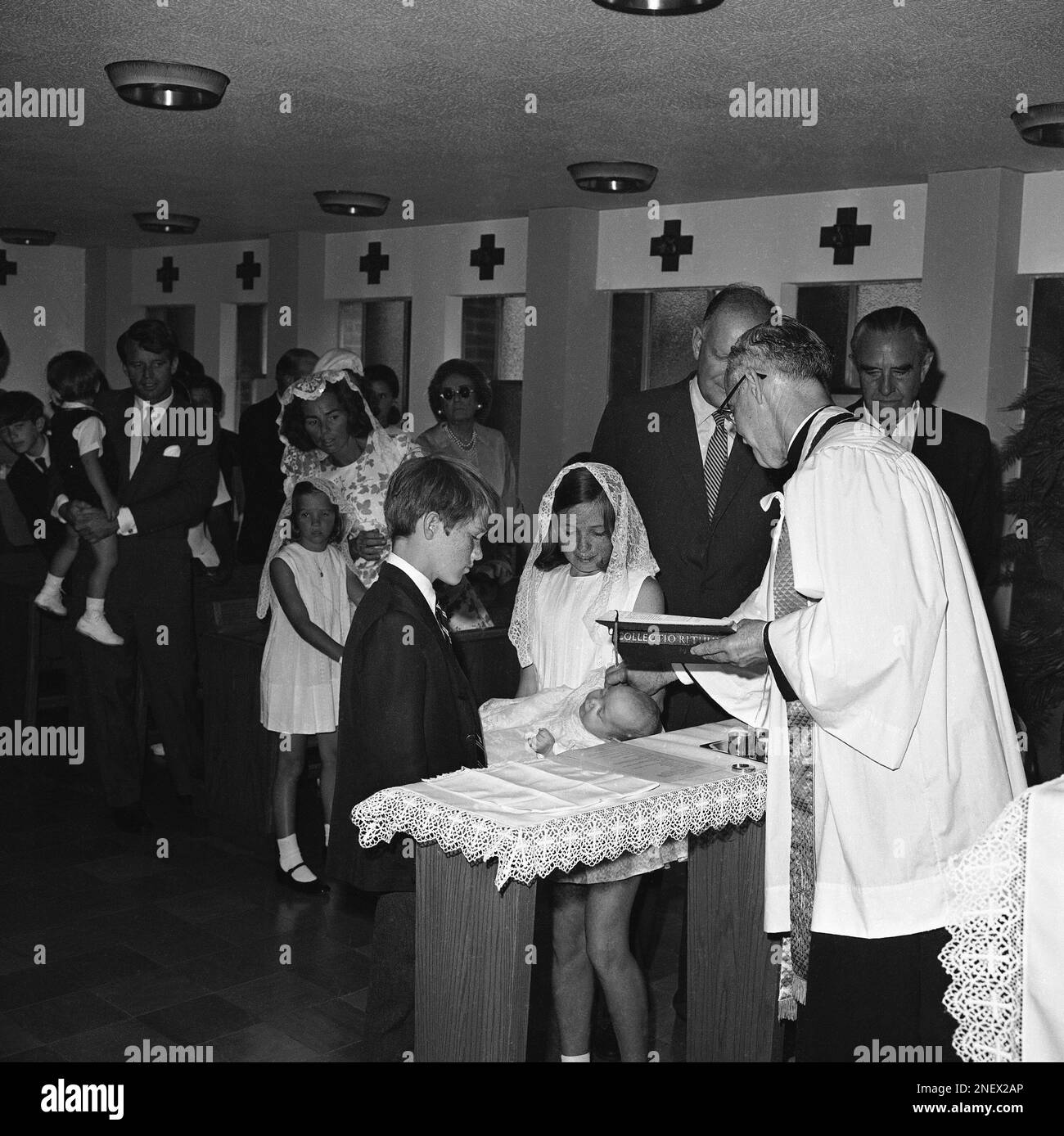 Father Albert Pereira presides over the rites of baptism for Douglas ...