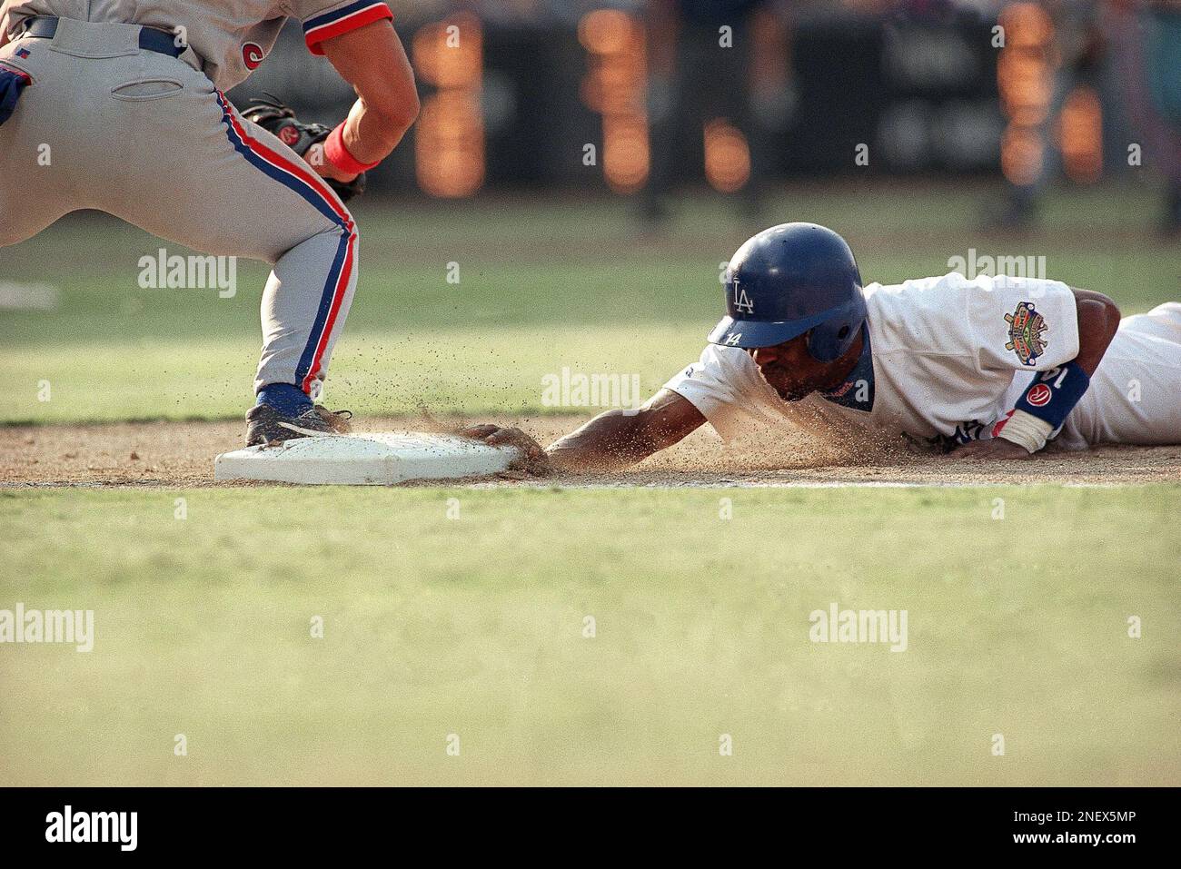 Los Angeles Dodgers' Delino Deshields slides back to first after a pick-off attempt from ...