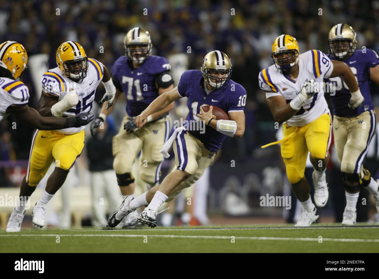 Washington quarterback Jake Locker carries the ball with LSU Lazarius ...