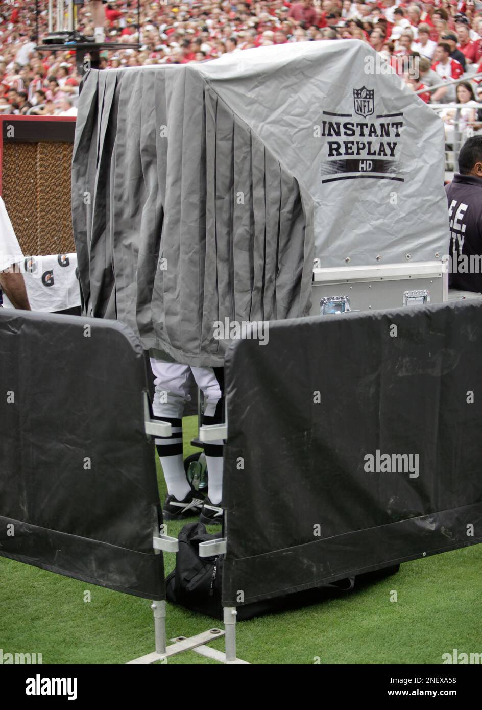A referee stands inside the instant reply booth during the first half ...