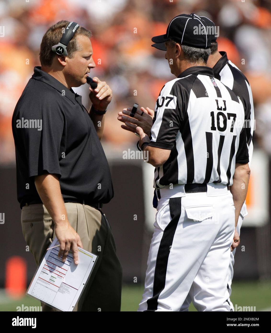 Cleveland Browns head coach Eric Mangini, left talks with line judge ...
