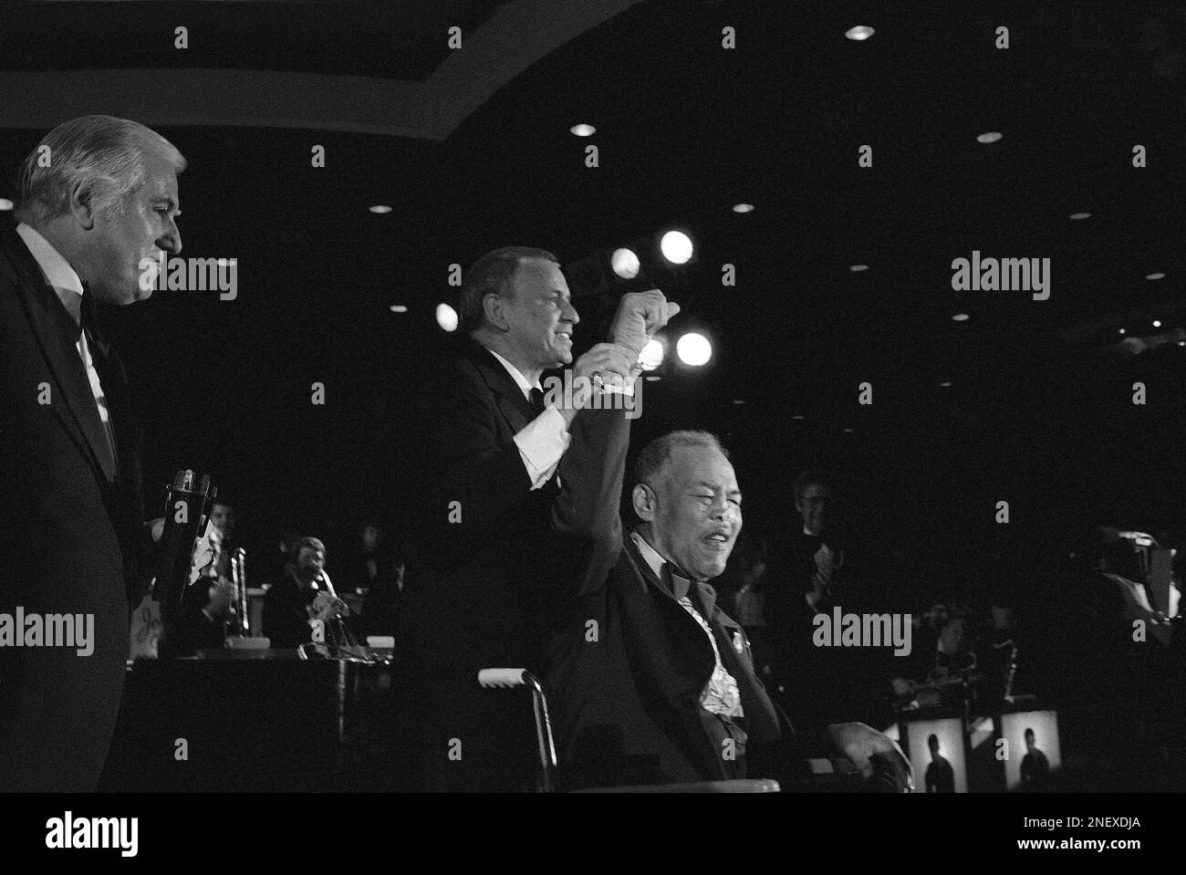 Entertainer Frank Sinatra, left, acting as master of ceremonies, helps ...