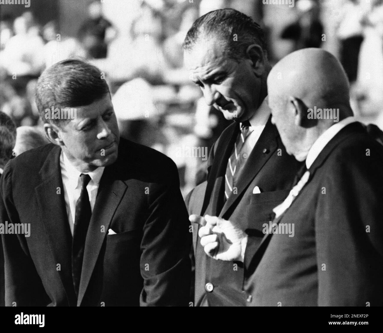 Sens. John F. Kennedy, left, and Lyndon B. Johnson bend an ear to ...