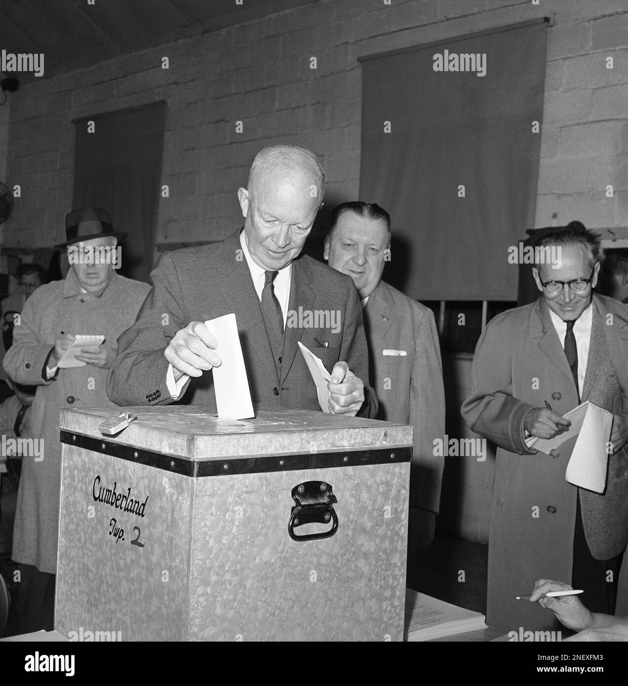President Eisenhower drops his ballot into the ballot box as he votes ...