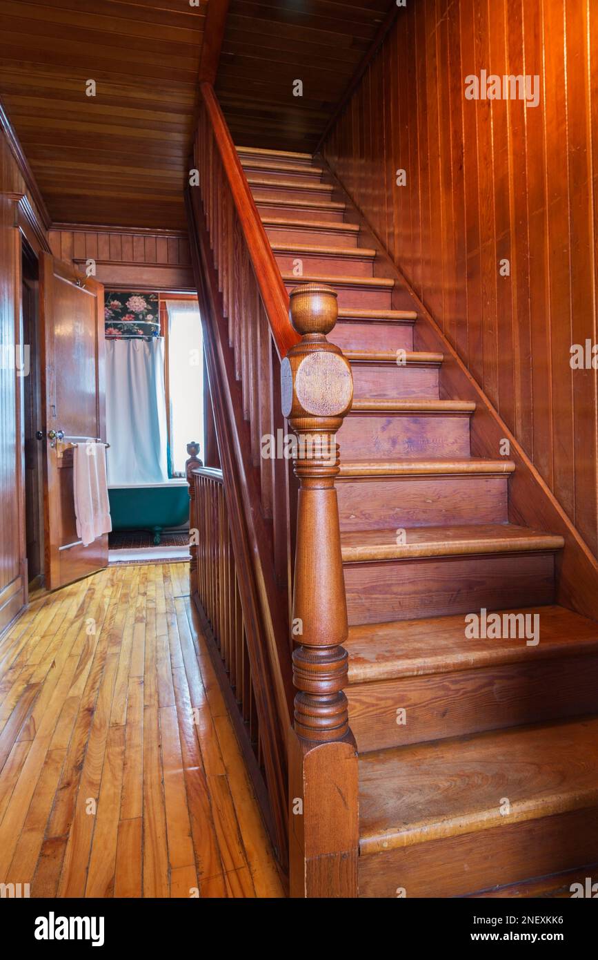 Wooden staircase leading to attic and opened door of main bathroom with ...