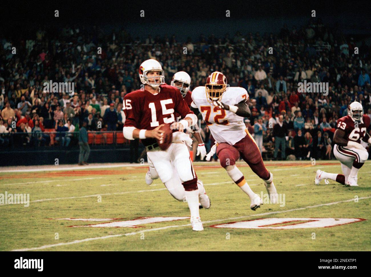 St. Louis Cardinals quarterback Neil Lomax, 15, is chased by Redskins ...