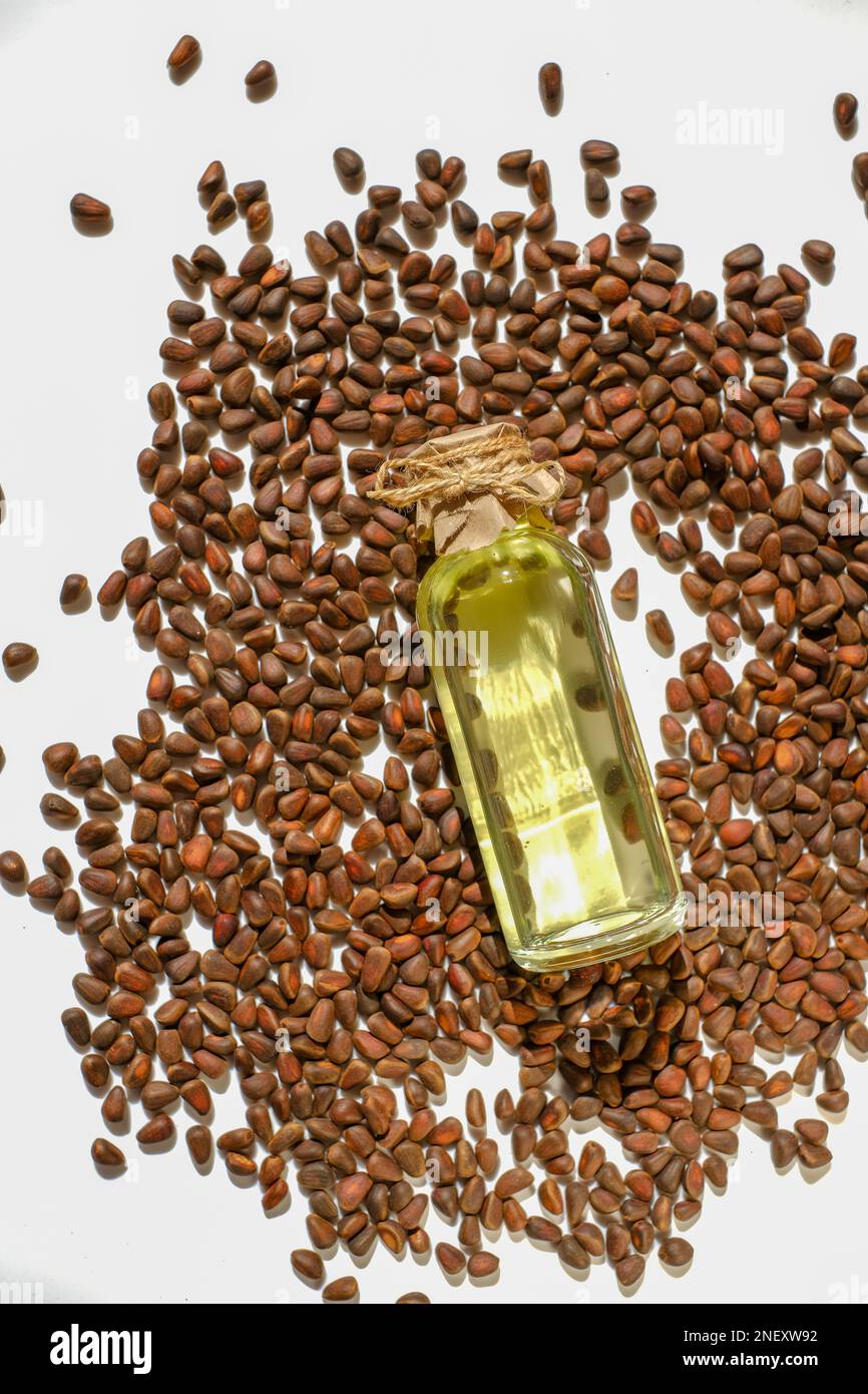 Pine nuts oil.shelled pine nuts and a bottle of cedar oil.glass bottle ...