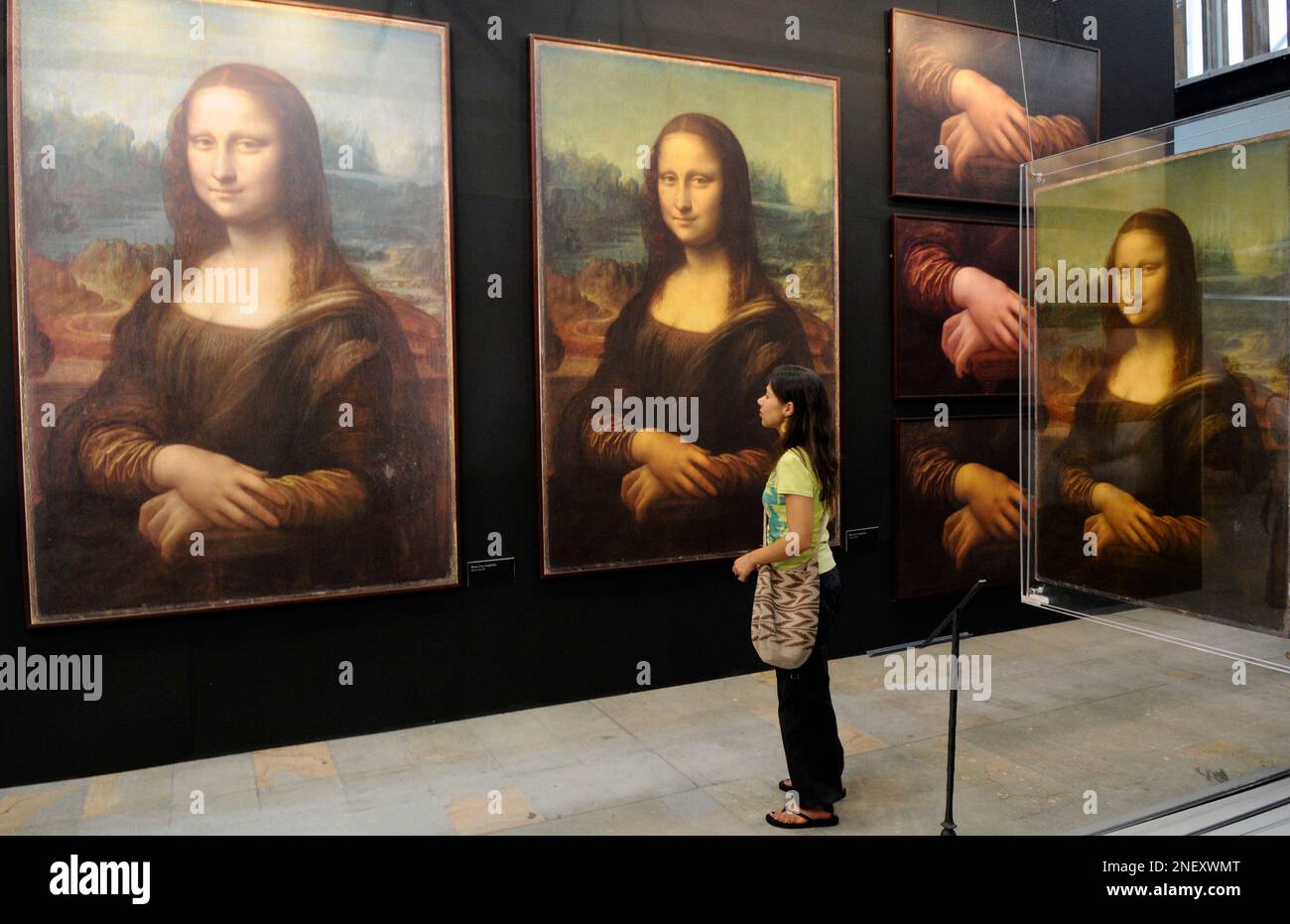 A visitor looks at replicas of Leonardo da Vinci's Mona Lisa at the "Da ...