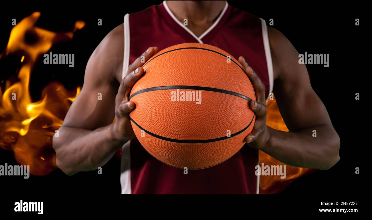 Composition of midsection of male basketball player holding ball over ...