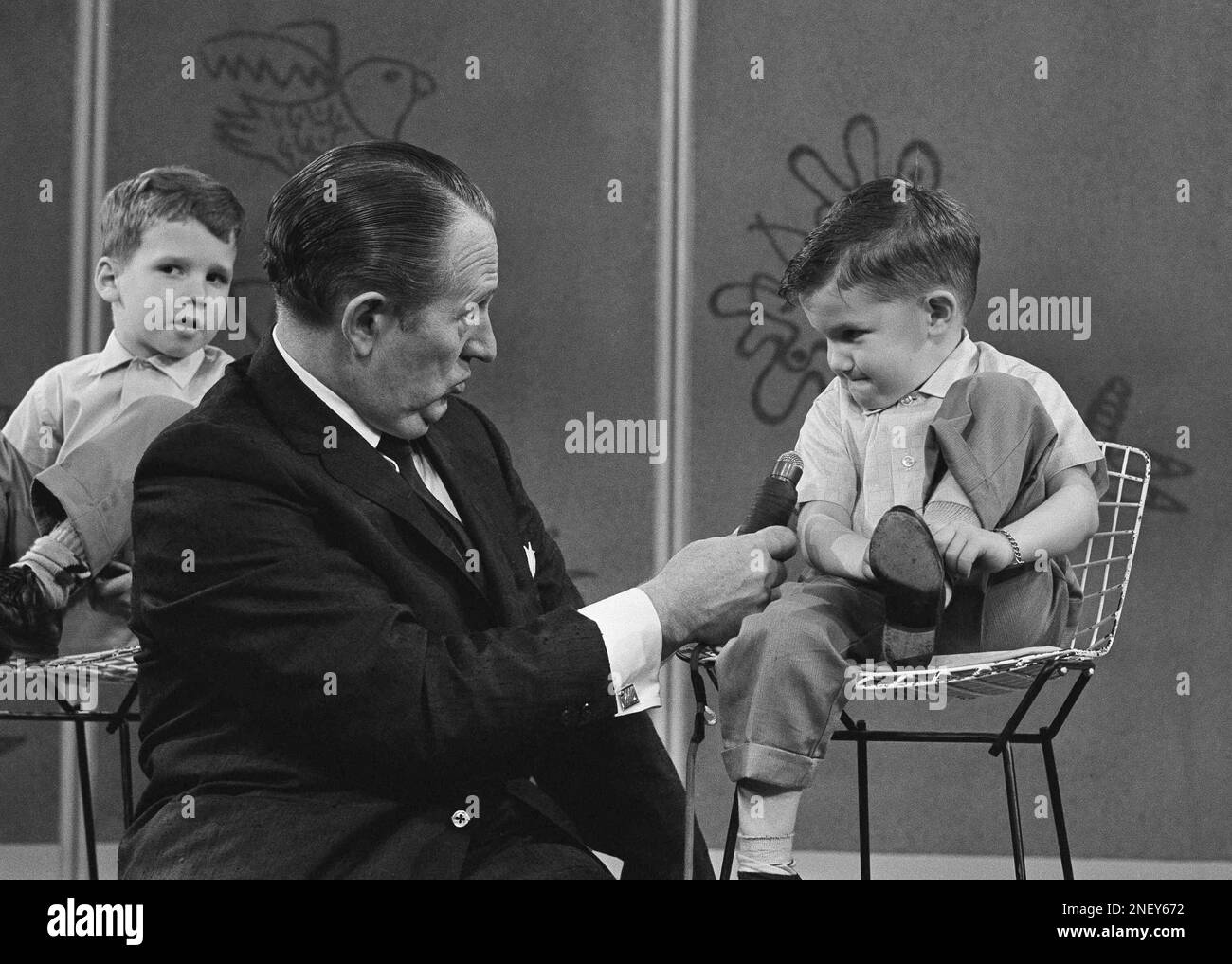 Making a face, 4-year-old Ronnie Glahn shows Art Linkletter his idea of ...