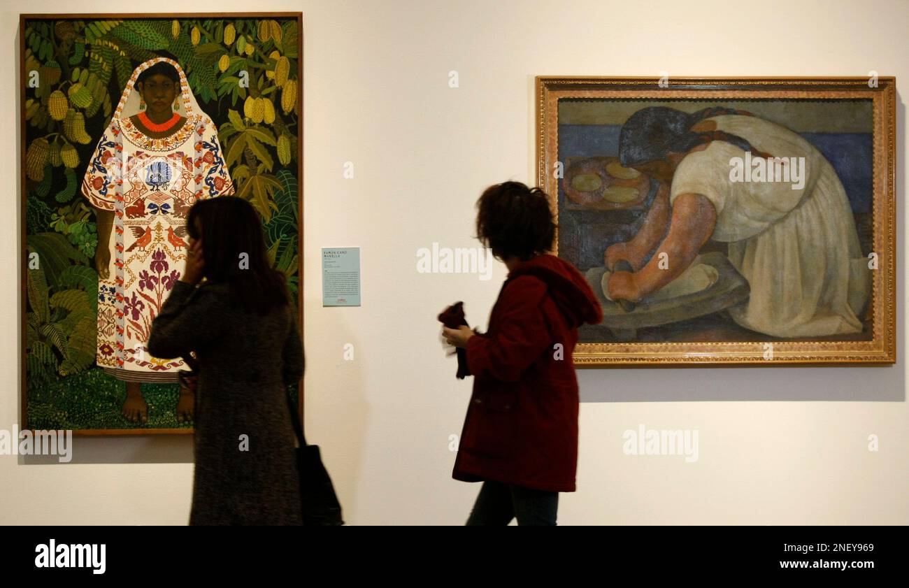 Visitors look at paintings of Mexican artists Diego Rivera, right, and ...