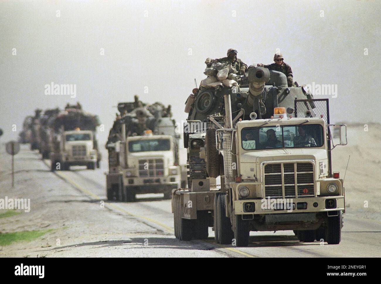 A military convoy of transport trucks carrying 155mm self-propelled ...