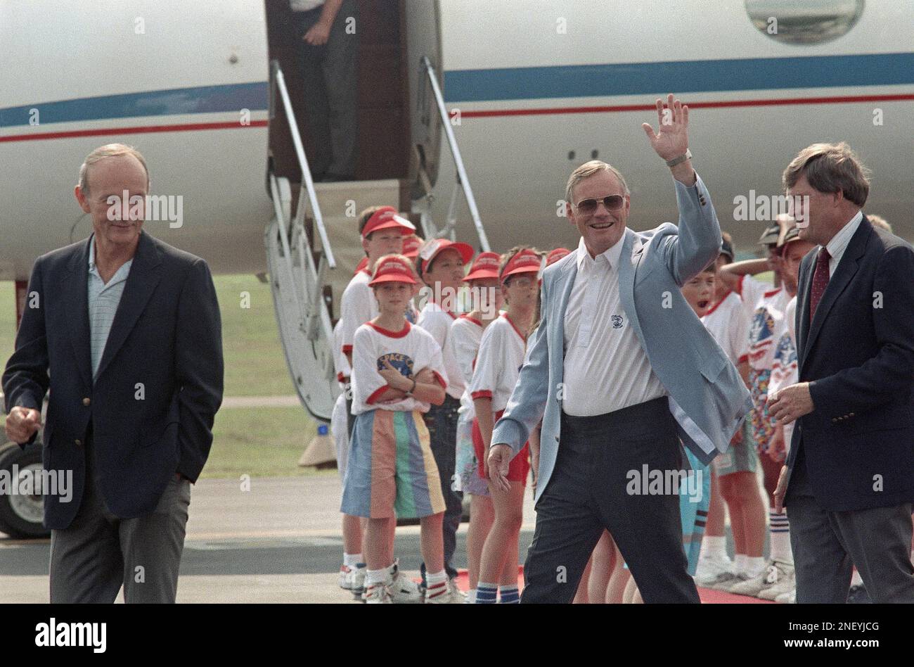 Apollo 11 astronaut Neil Armstrong, center, waves as he arrives ...