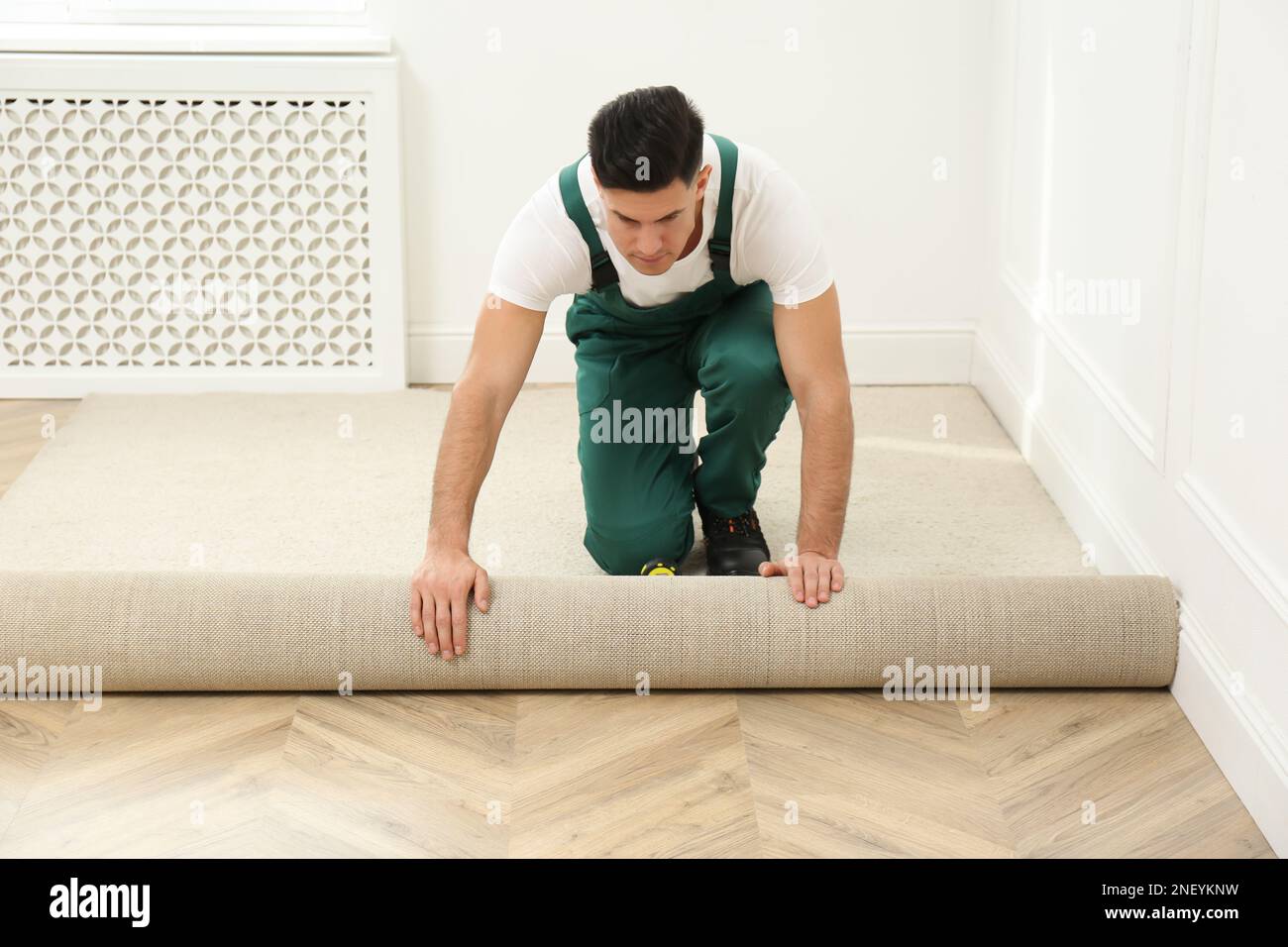 Worker rolling out new carpet in room Stock Photo - Alamy Worker rolling out new carpet in room Stock Photo - Alamy