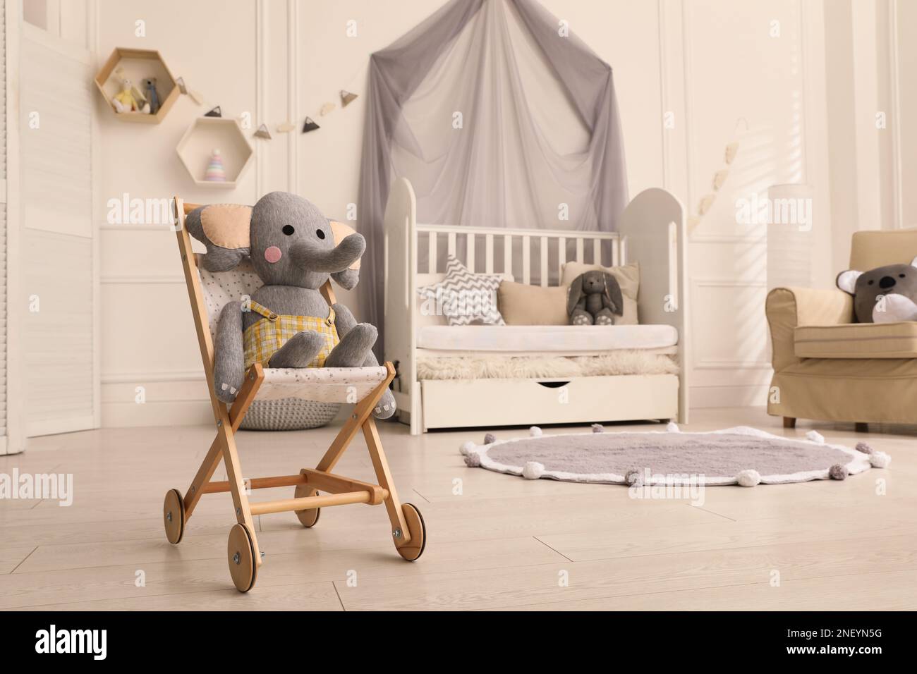 Buggy with elephant toy in baby room, space for text. Interior design ...