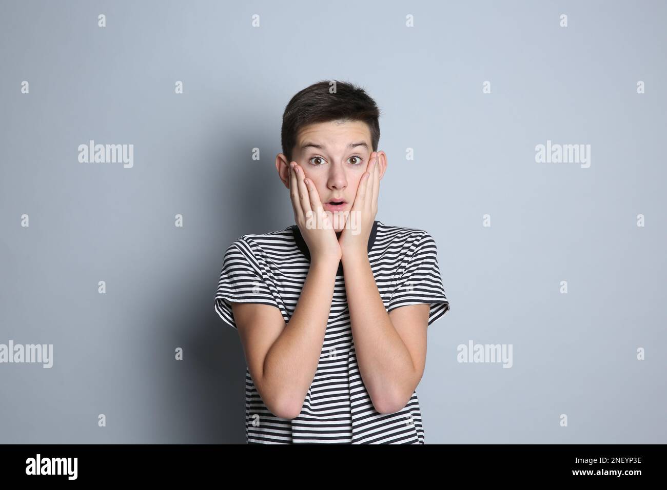 Portrait of surprised teenage boy on grey background Stock Photo - Alamy