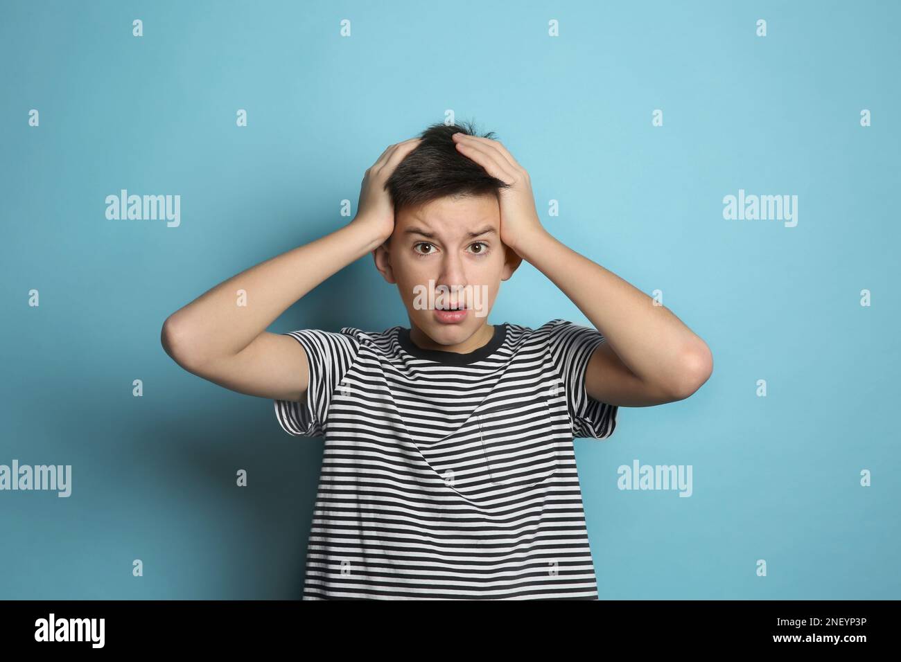 Worried teenage boy on light blue background Stock Photo - Alamy
