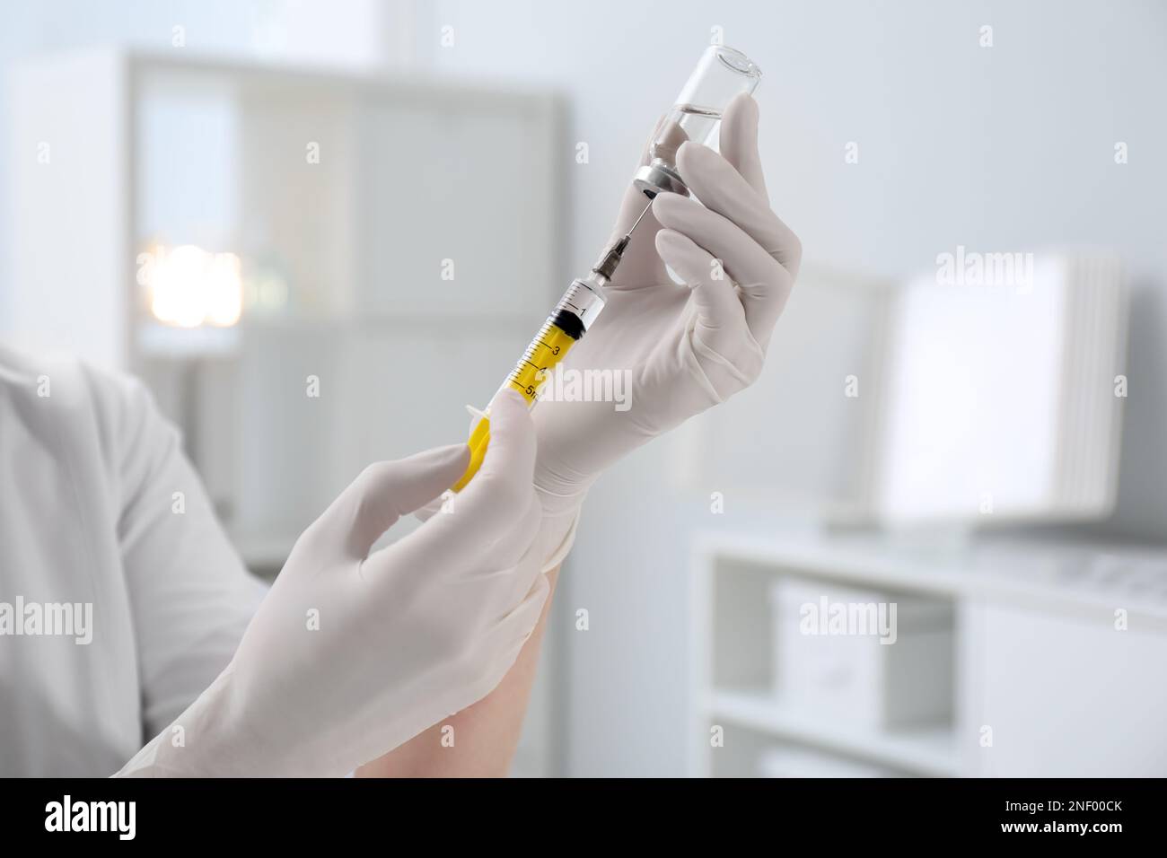 Doctor filling syringe with medication from vial in hospital, closeup ...