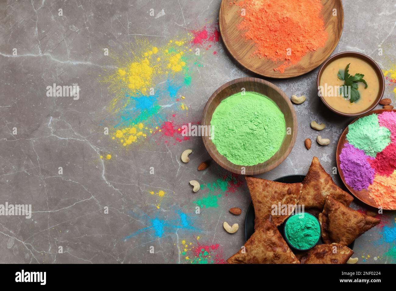 Traditional Indian food and color powders on grey table, flat lay with ...