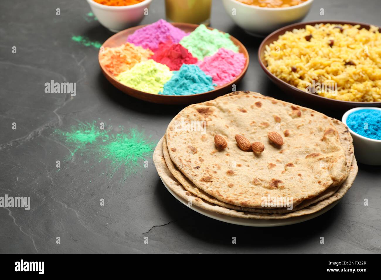 Traditional Indian food and color powders on black table. Holi festival ...